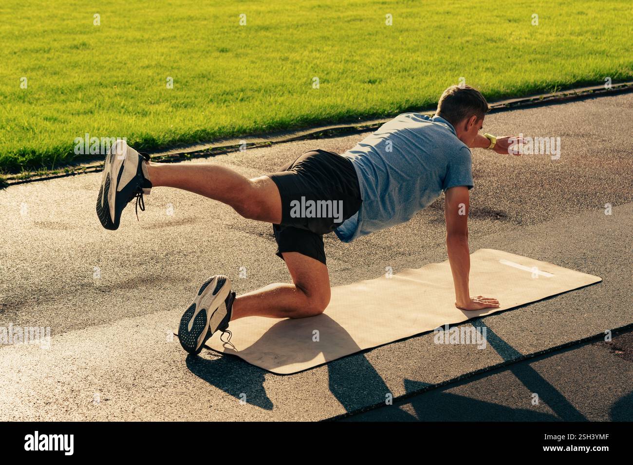 Active individual performing an exercise routine on a mat in a park ...