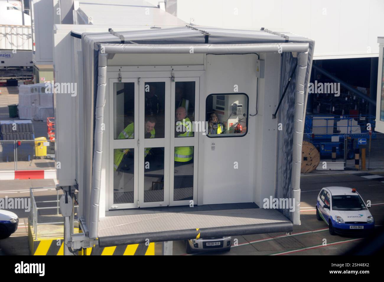 A Passenger Boarding Bridge (PBB) being manned by airport ground staff ...