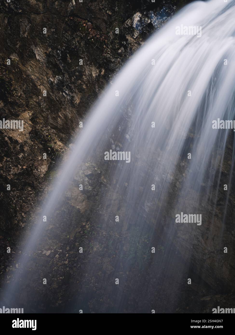 A detailed view of a waterfall's flowing water, captured as it cascades ...