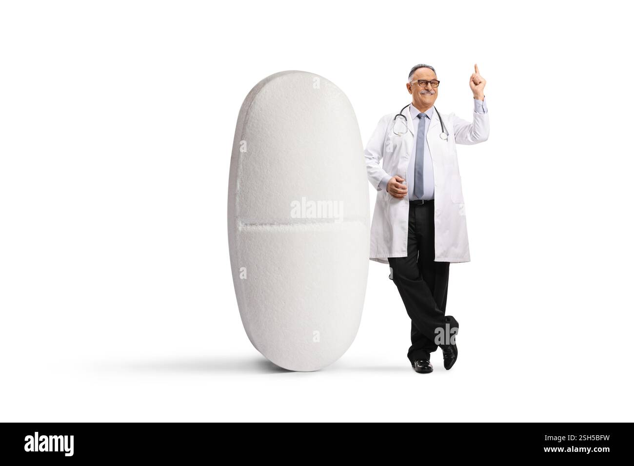 Doctor with a big pill pointing up isolated on white background Stock ...