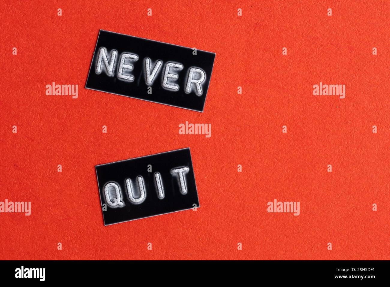Never Quit text on blackboard on red background. Motivational concept ...