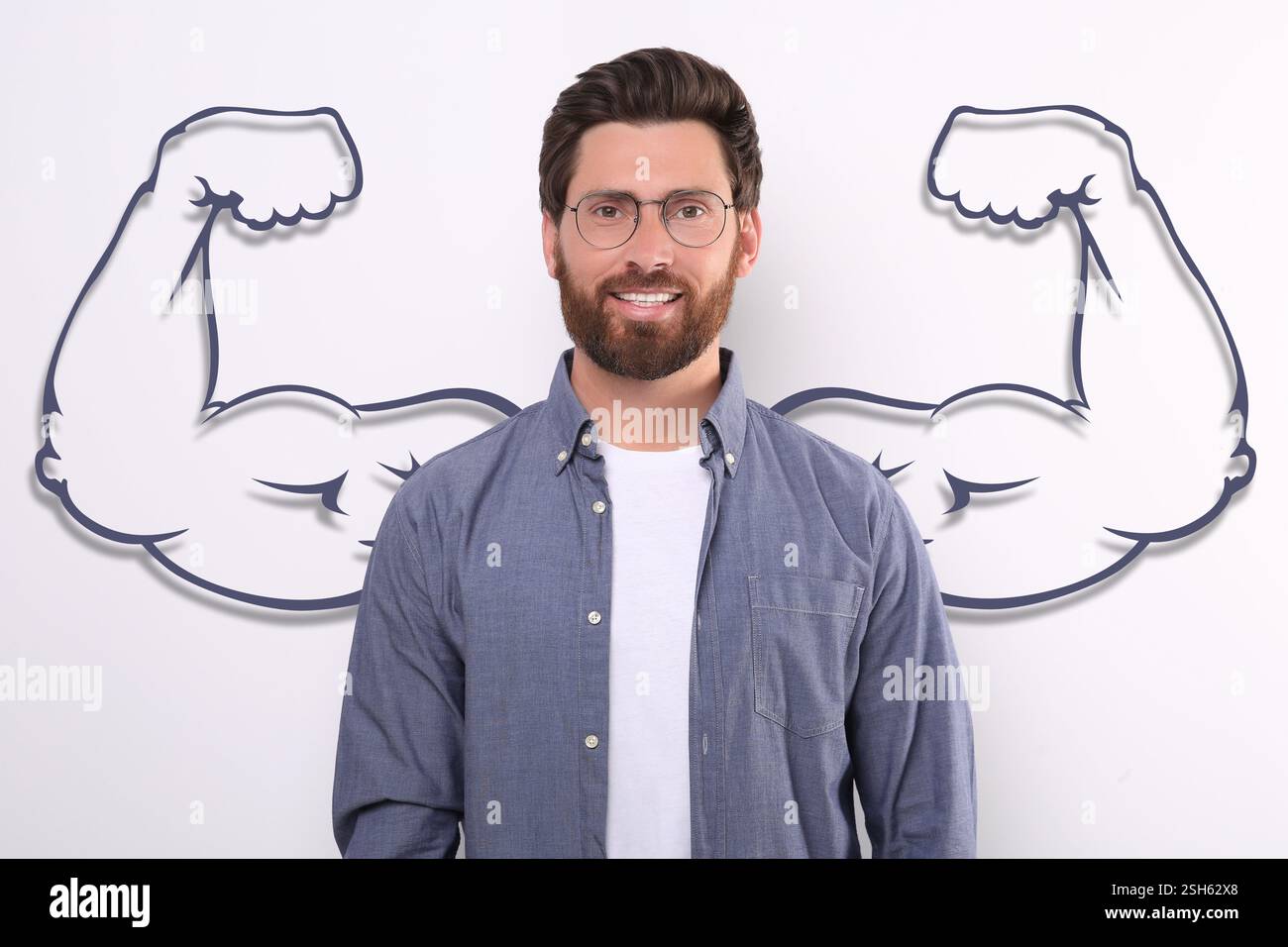 Handsome man with drawing of strong arms behind him on white background ...