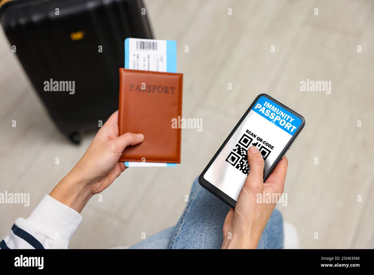 Tourist with passport, flight ticket and mobile phone indoors, above ...