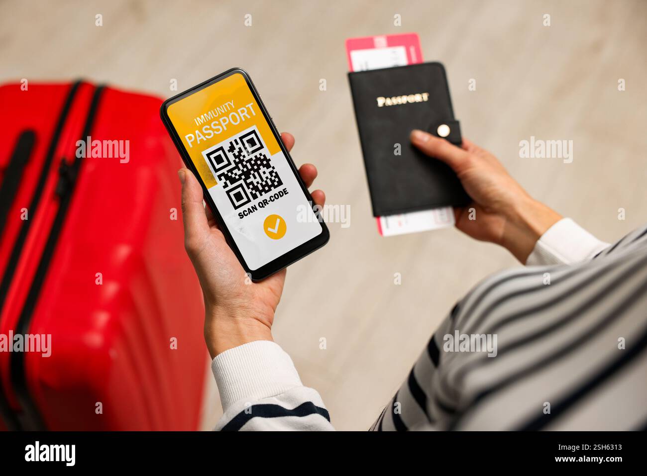 Tourist with passport, flight ticket and mobile phone indoors, above ...