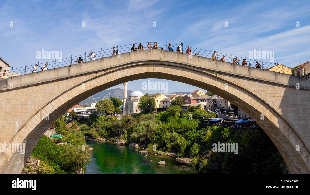 Tourists on the famous old arch bridge in Mostar. Close-up view of the ...