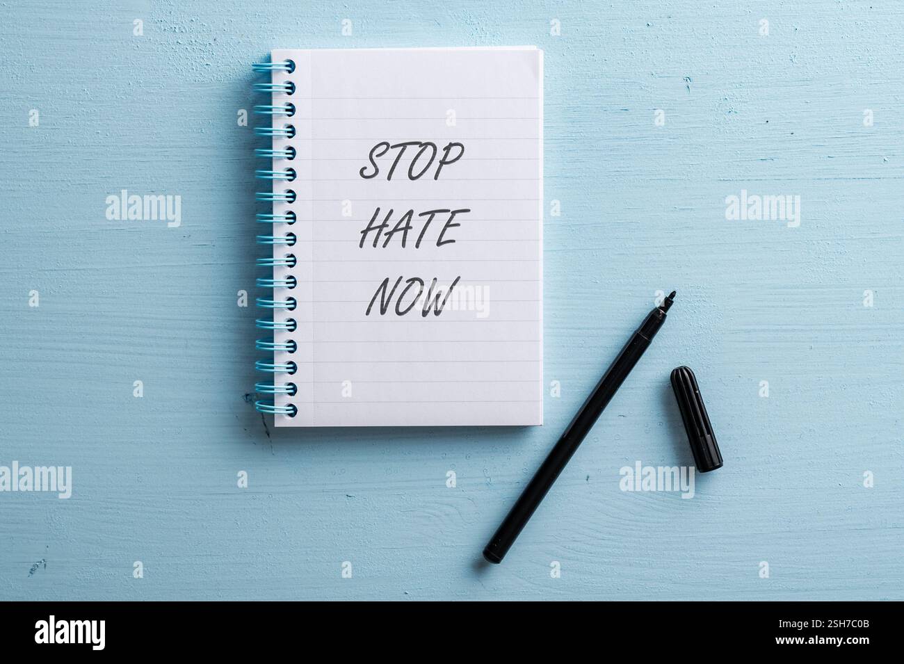 Stop hate now sign written with black marker in a white spiral notebook ...