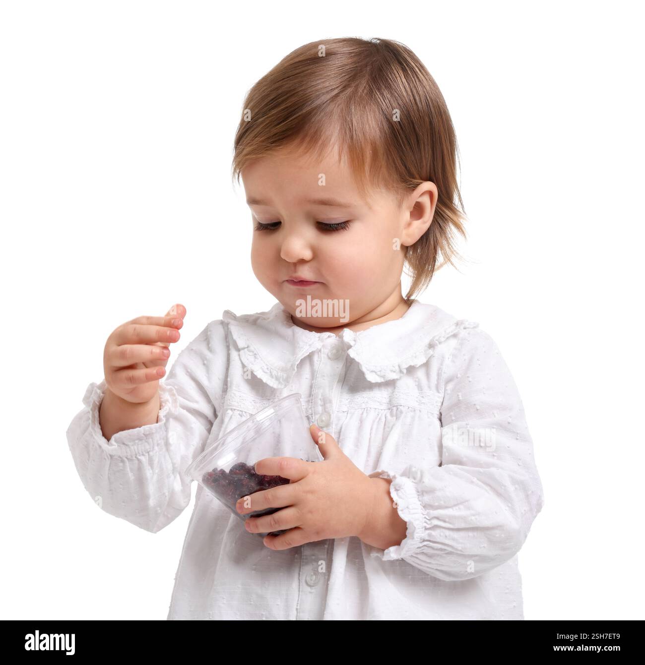 Cute little baby girl eating snack on white background Stock Photo - Alamy
