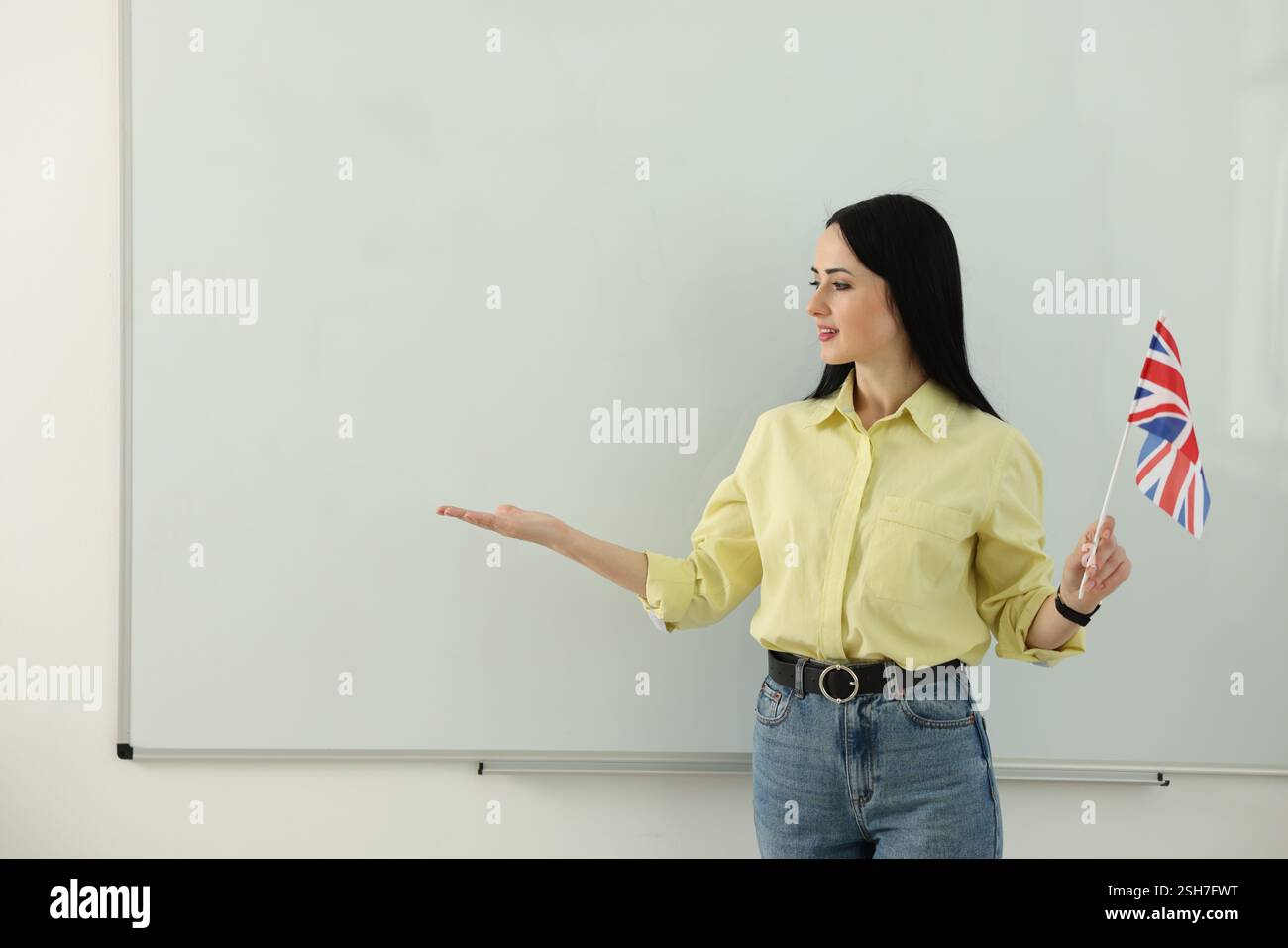 English teacher explaining something near whiteboard in classroom ...