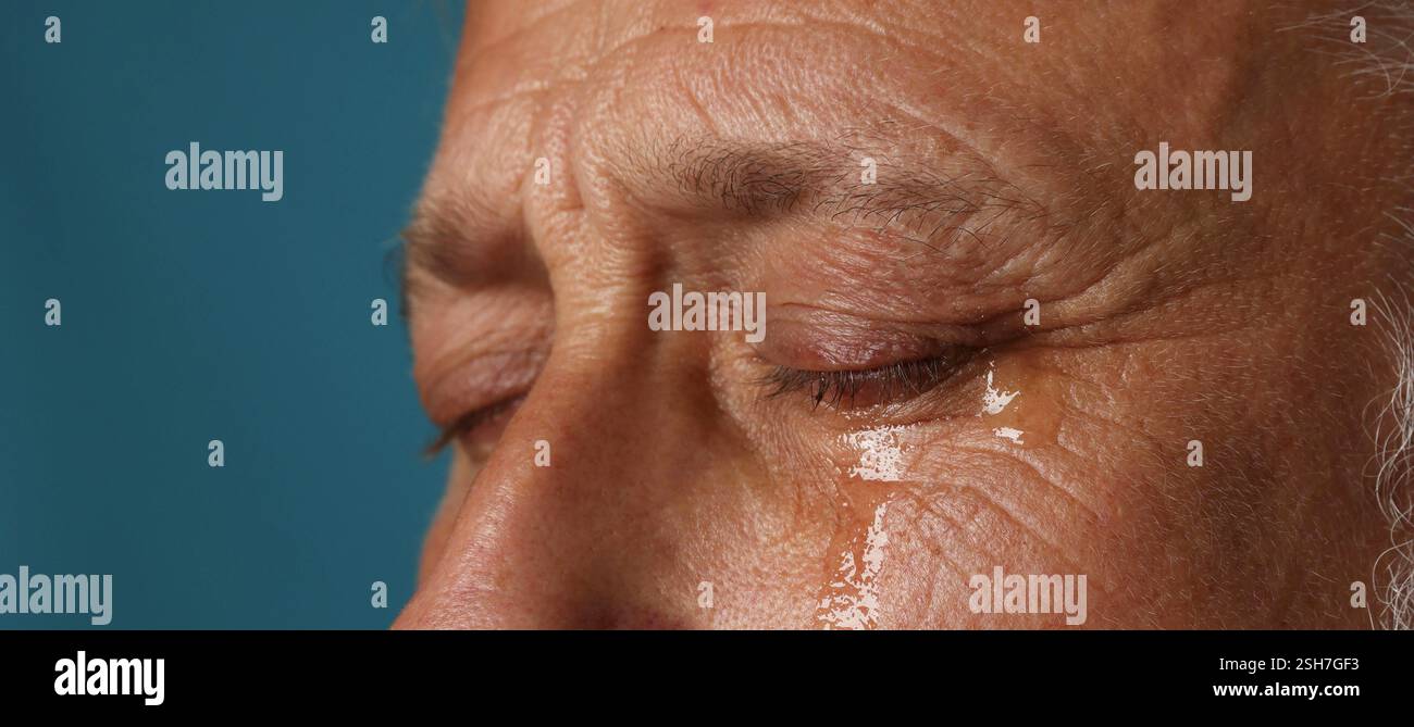 Sad senior man crying on blue background, closeup Stock Photo - Alamy