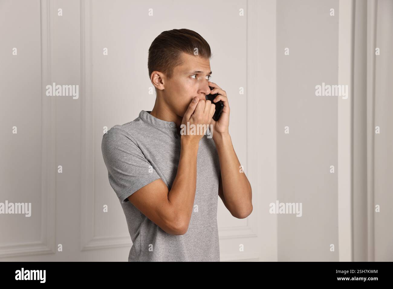 Stressed man calling hotline for mental health help indoors Stock Photo ...