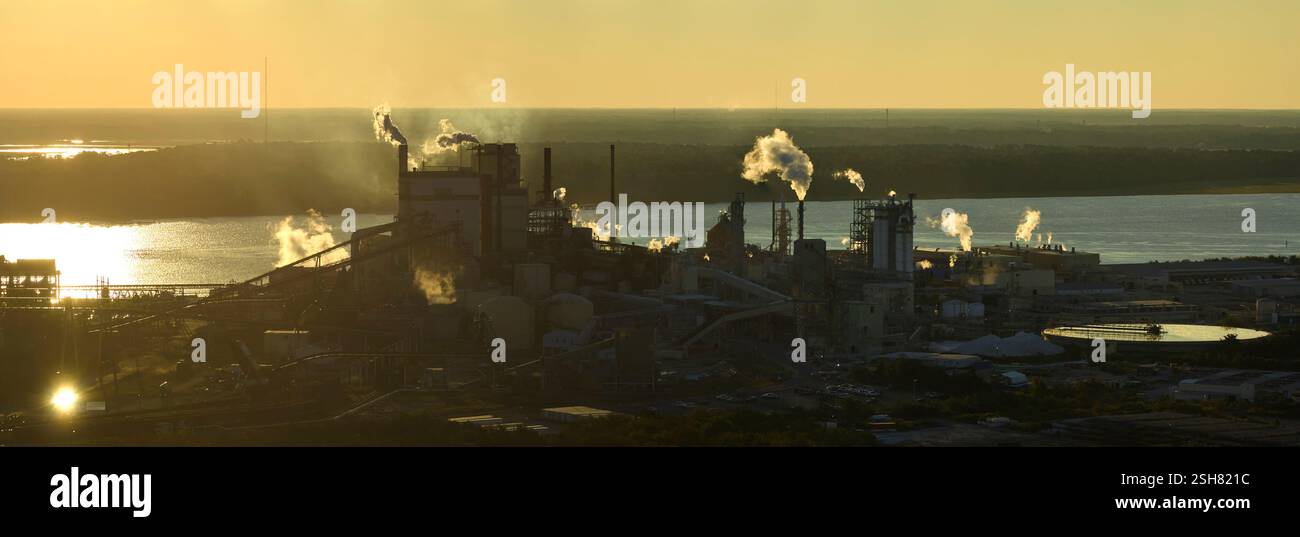 Large factory structure with smoke from production process rising up ...