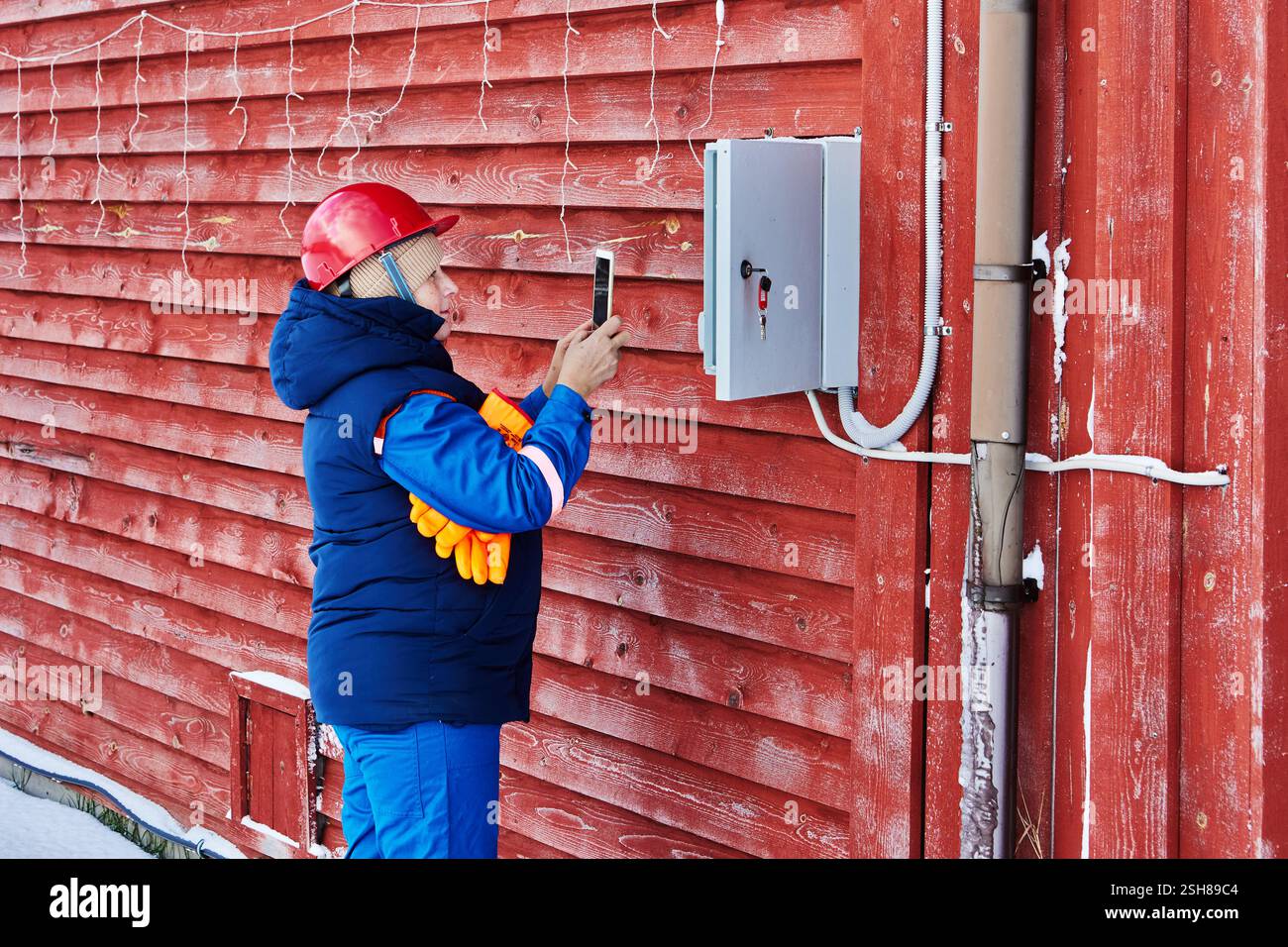 Power company worker checking functionality of an electrical meter box ...