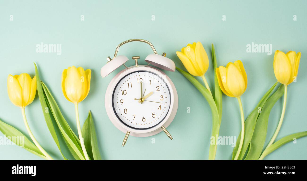 Alarm clock with yellow tulip flowers, switch to daylight saving time ...