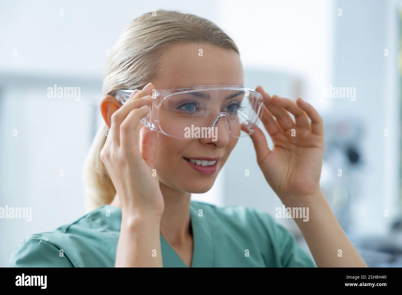 Professional woman biologist wearing safety glasses working in ...