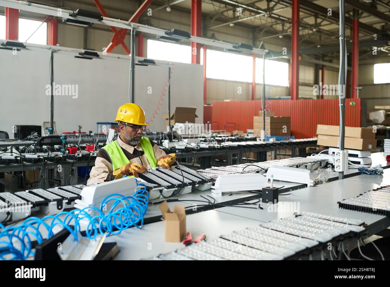 Mature male worker of modern factory producing electric equipment ...