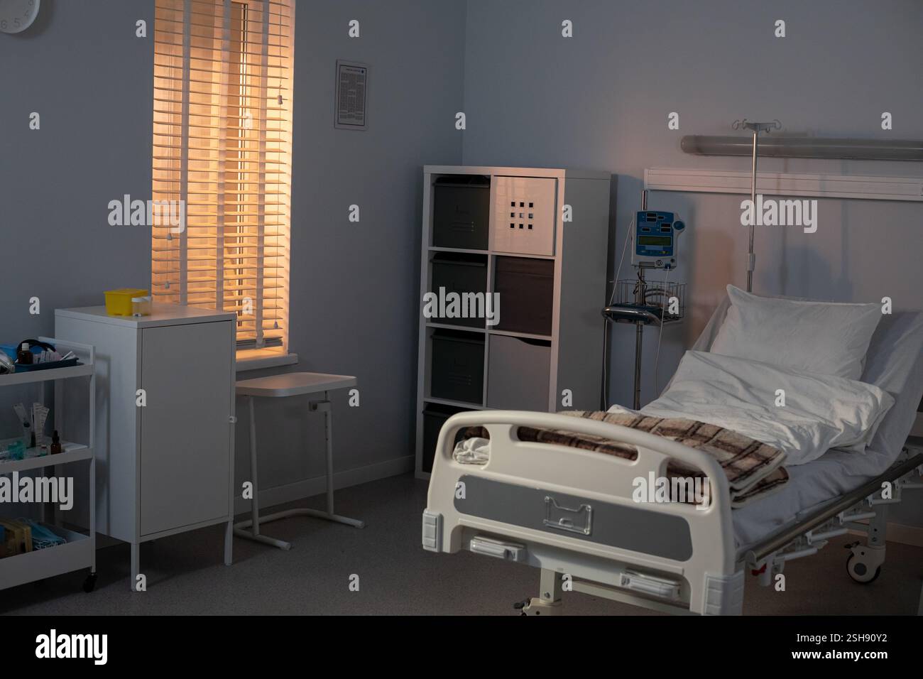 A calm and sterile hospital room featuring a patient bed, designed with ...