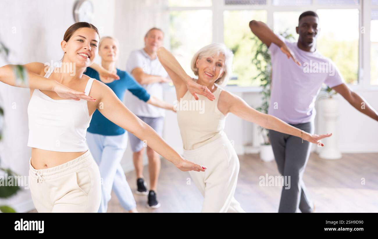 Female instructor teaches mature students of dance class basic ...