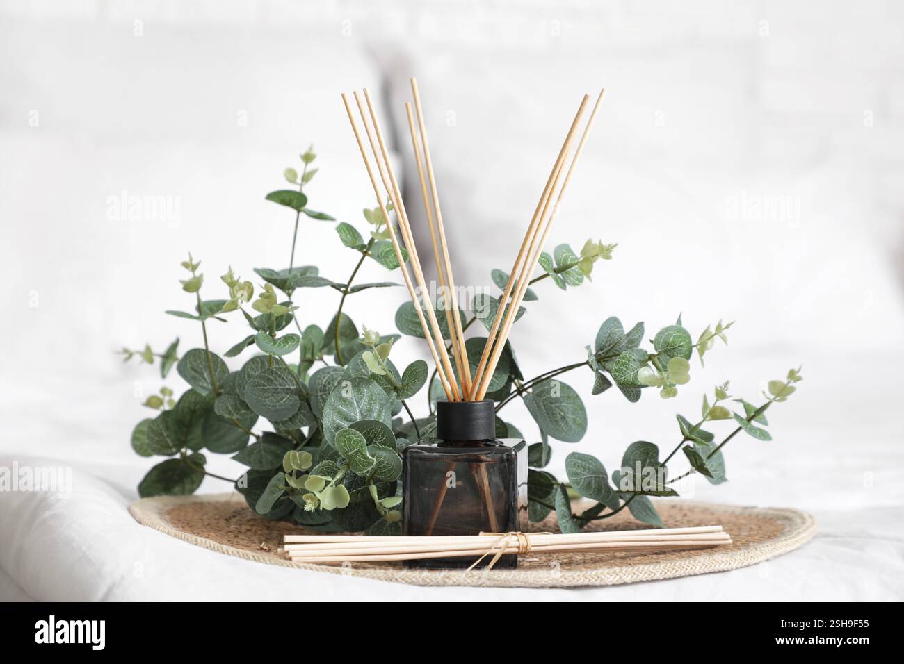 Reed diffuser with sticks and eucalyptus on bed Stock Photo - Alamy