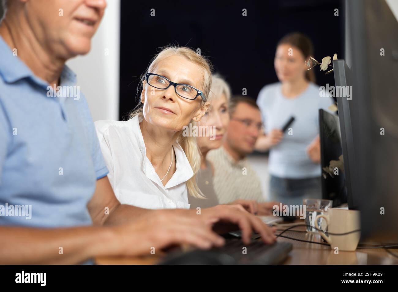 Computer lessons for elderly people in nursing home. Group of seniors ...