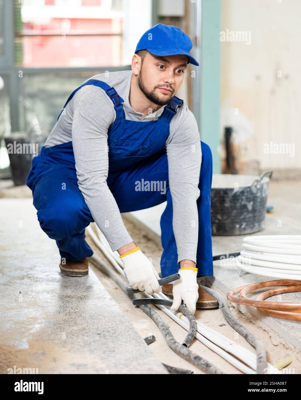 Man electrical installer laying cables through trench Stock Photo - Alamy