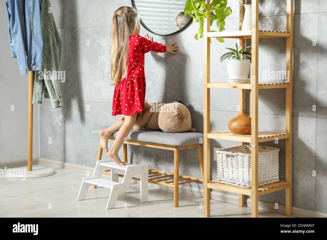 Little girl standing on step stool at home Stock Photo - Alamy