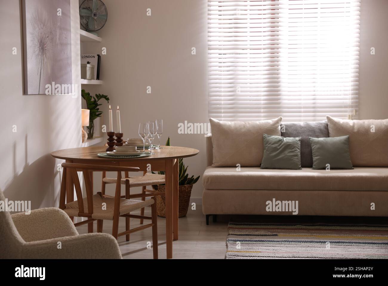 Stylish table setting, chairs and sofa in dining room. interior design ...