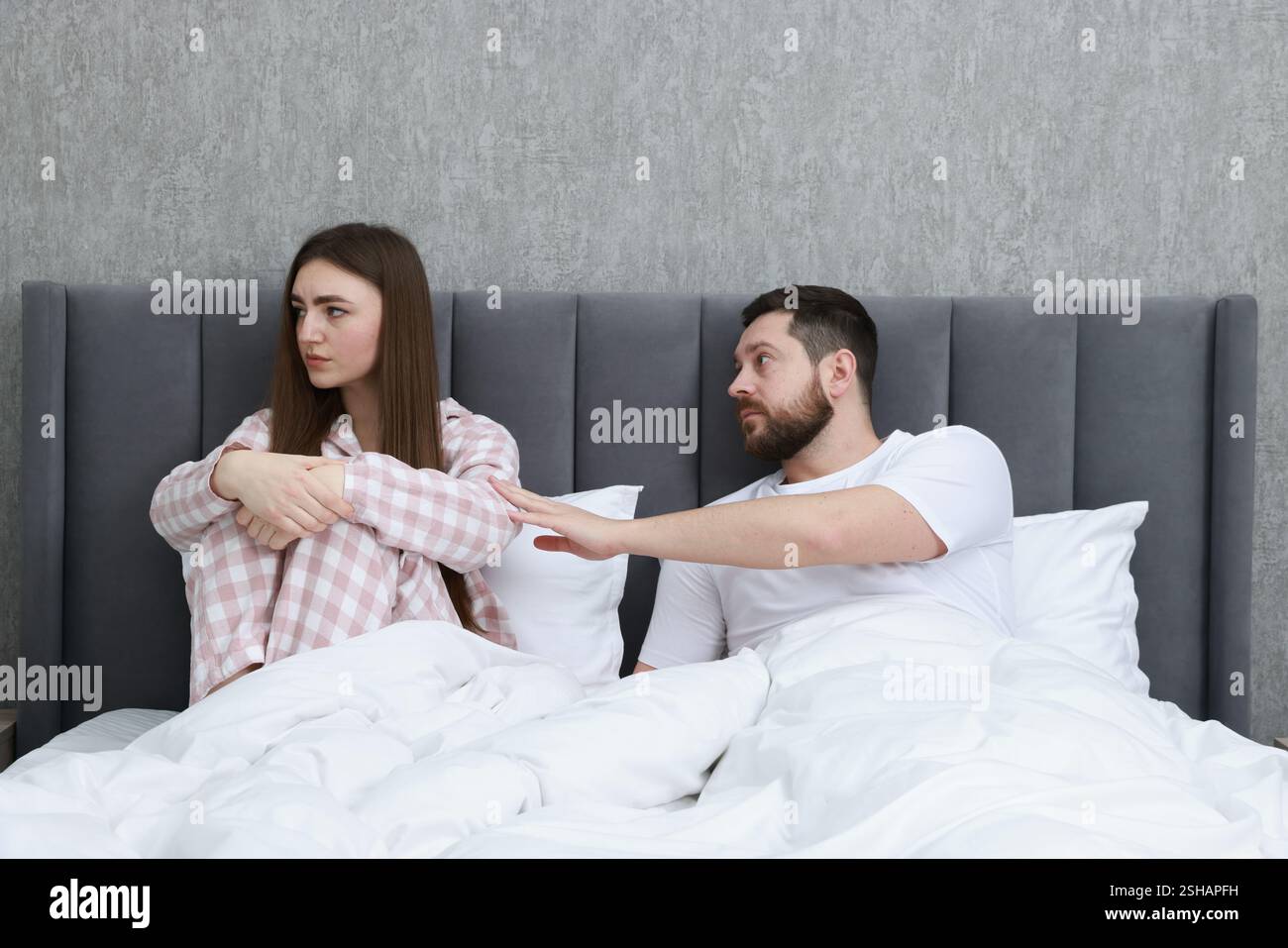 Man comforting his resentful girlfriend on bed at home Stock Photo - Alamy