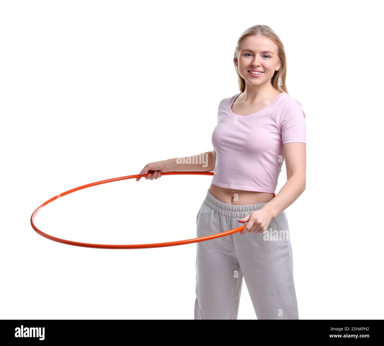 Beautiful young woman exercising with hula hoop on white background ...