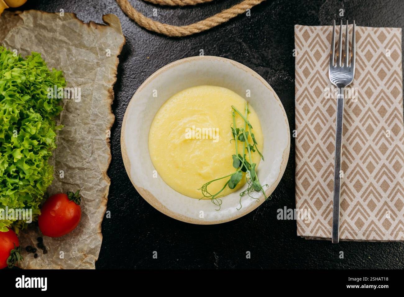 Creamy mashed potatoes garnished with fresh microgreens, in stylish and ...