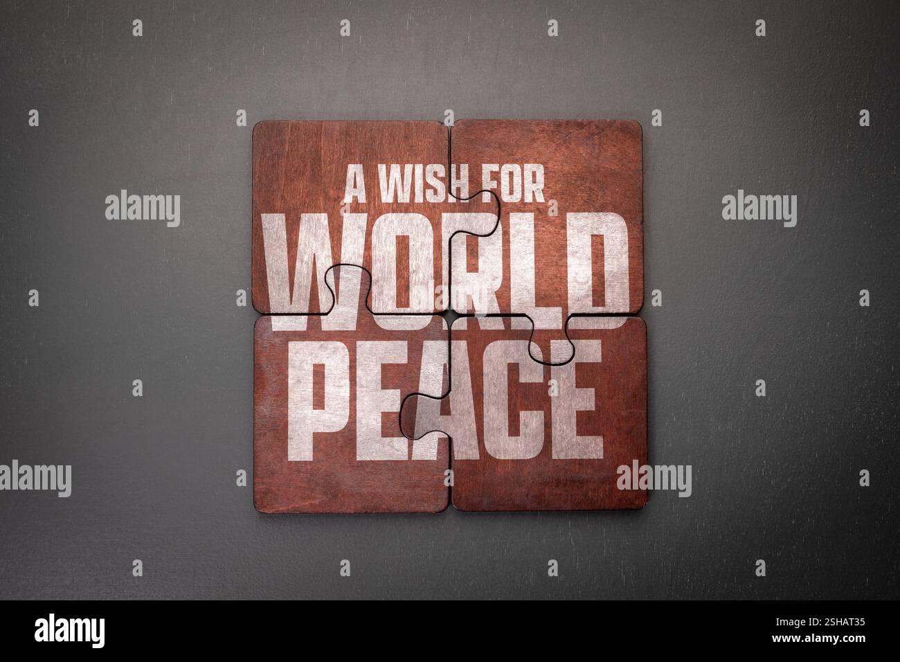 A Wish for World Peace. Wooden puzzle pieces with text on a dark office ...