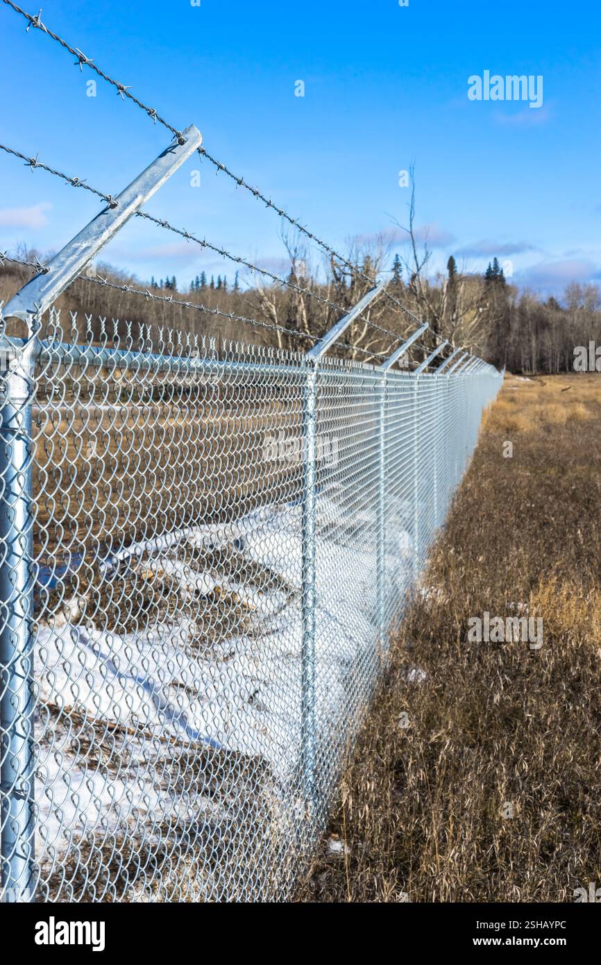 Net fence with barbed wire deviding private and public space (vertical ...