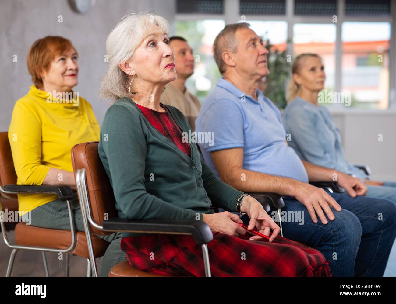 Group of older students sitting and listening at lesson Stock Photo - Alamy
