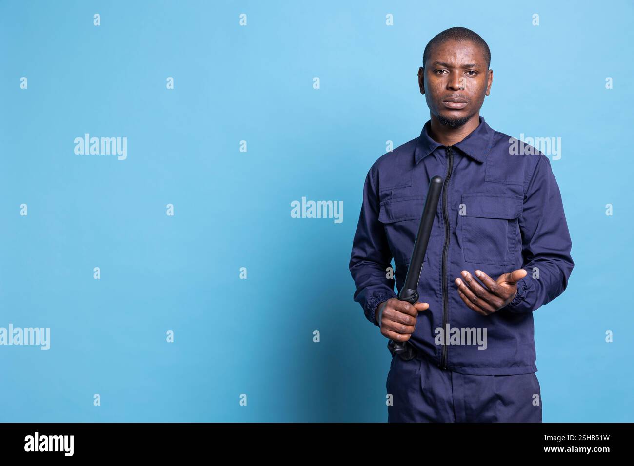 Security agent holding his baton weapon while being on duty, working on ...