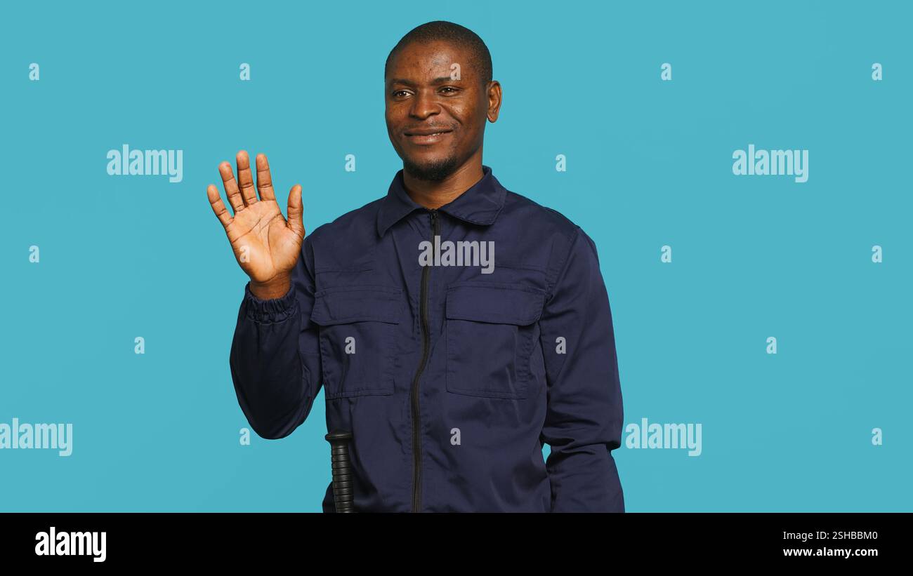 Upbeat security guard greeting people, preventing criminal activity and ...