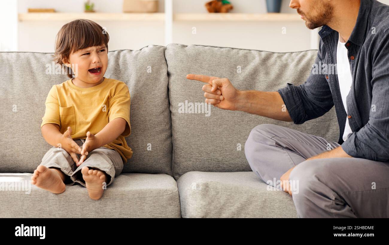 Domestic violence and kids abuse. Furious angry daddy shouling at his little son, crying boy ...