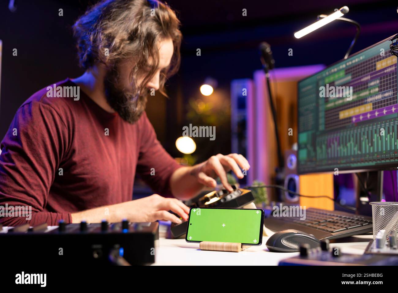 Composer singer mixing tunes on soundboard in home studio, editing next ...