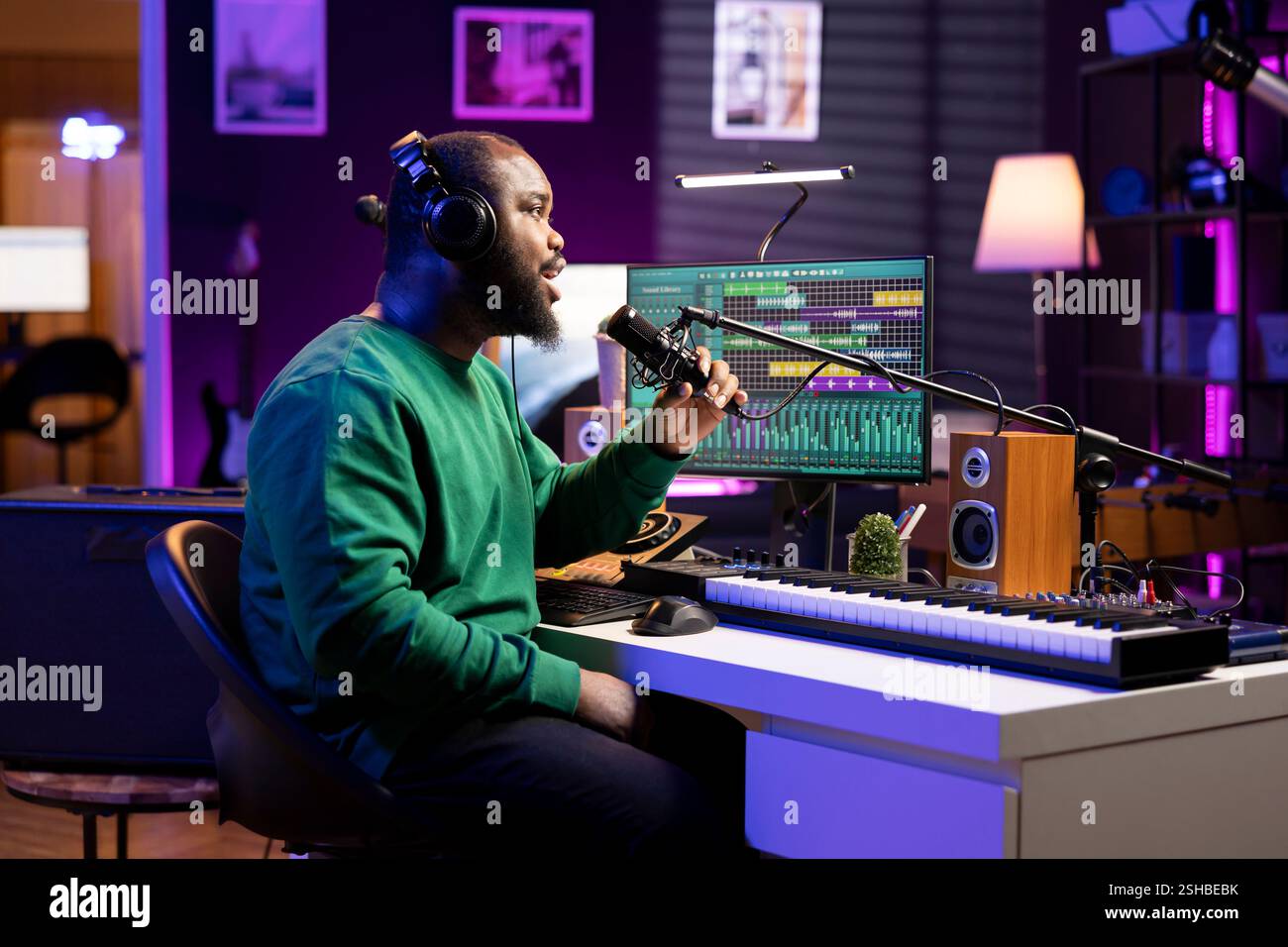 Artist composer recording a new track on his home studio microphone ...