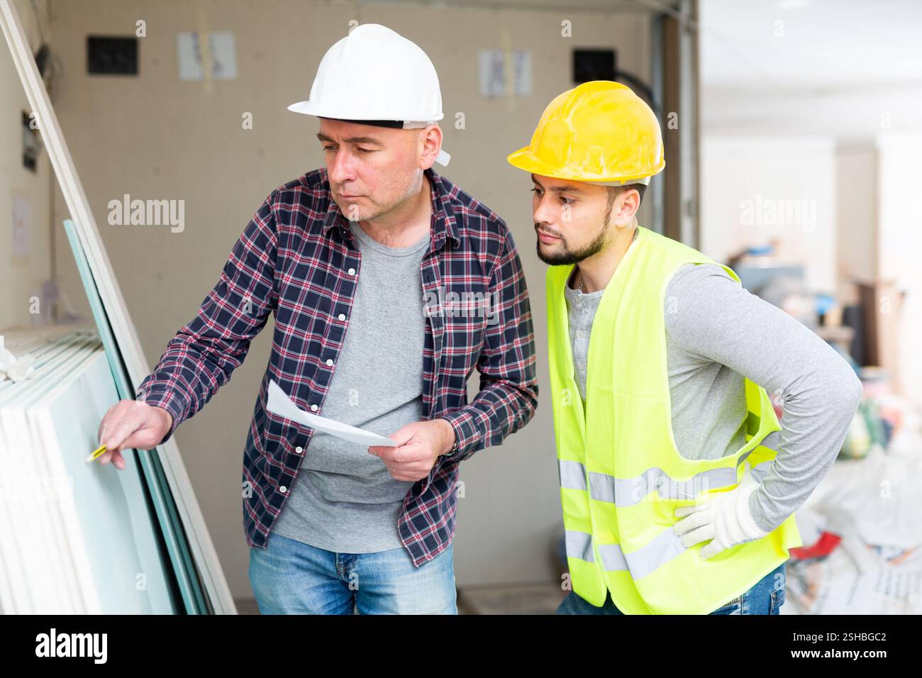 Civil engineer giving instructions to foreman in building under ...