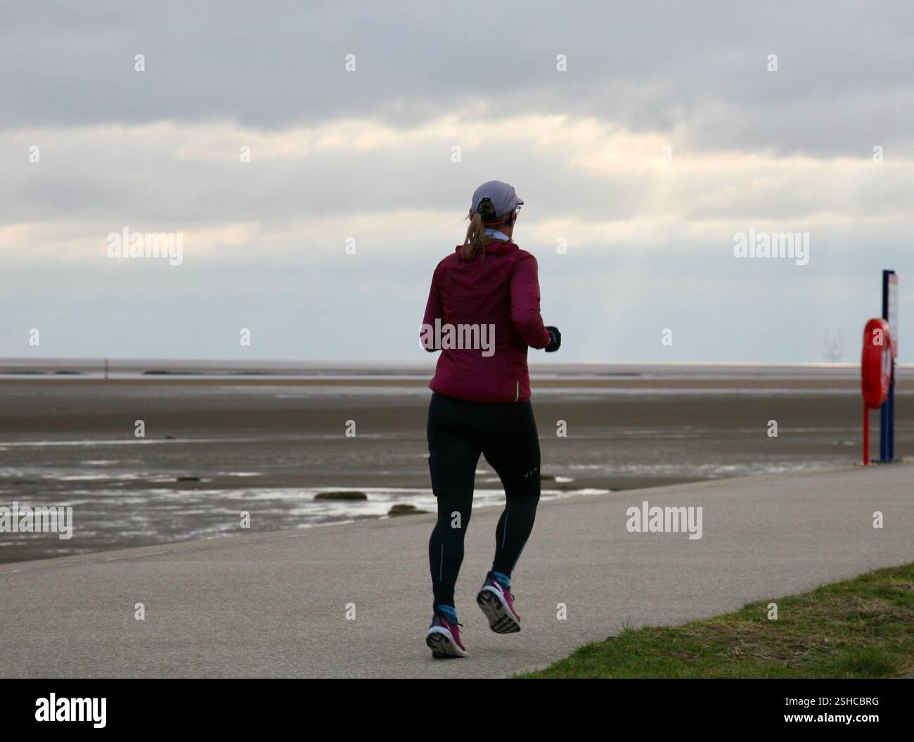 A lone runner on the seafront Stock Photo - Alamy