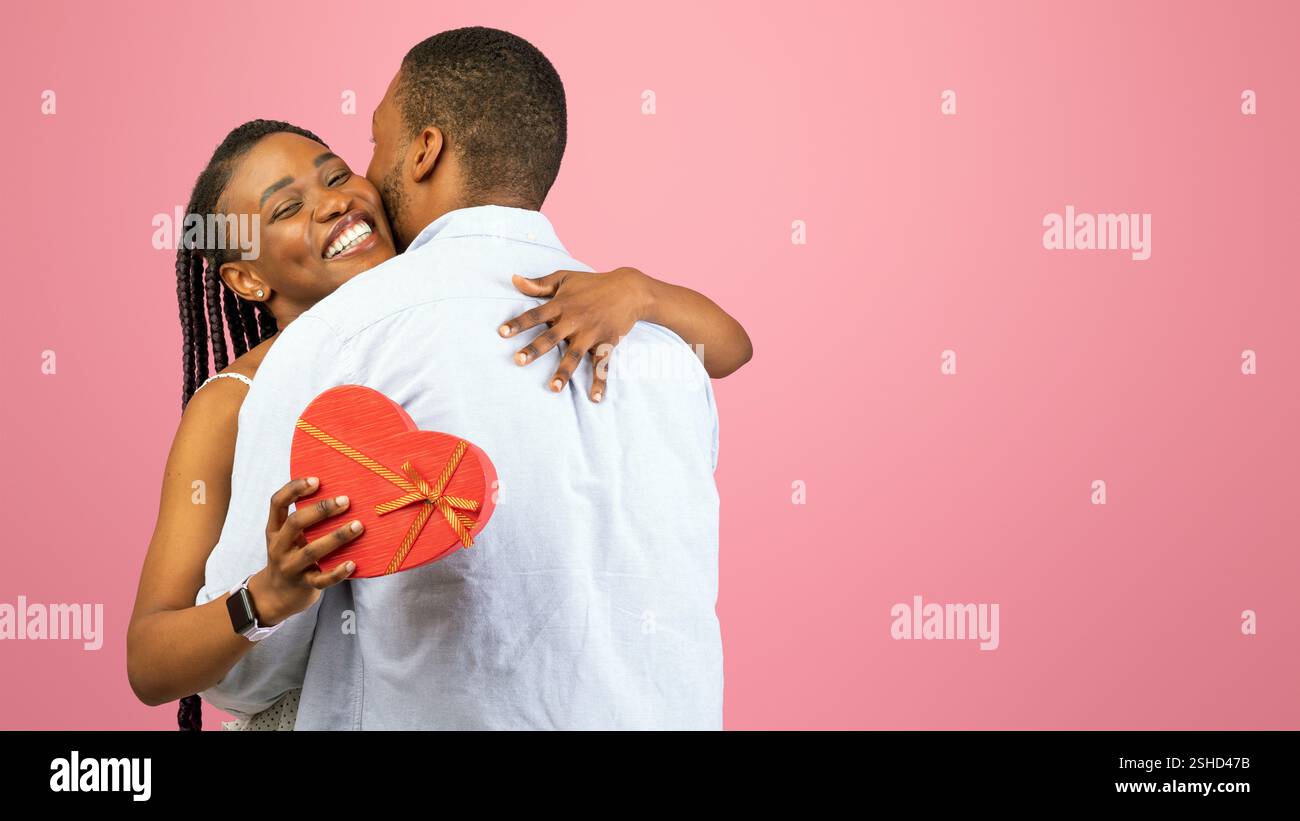 Happy black man making surprise for woman giving box Stock Photo - Alamy