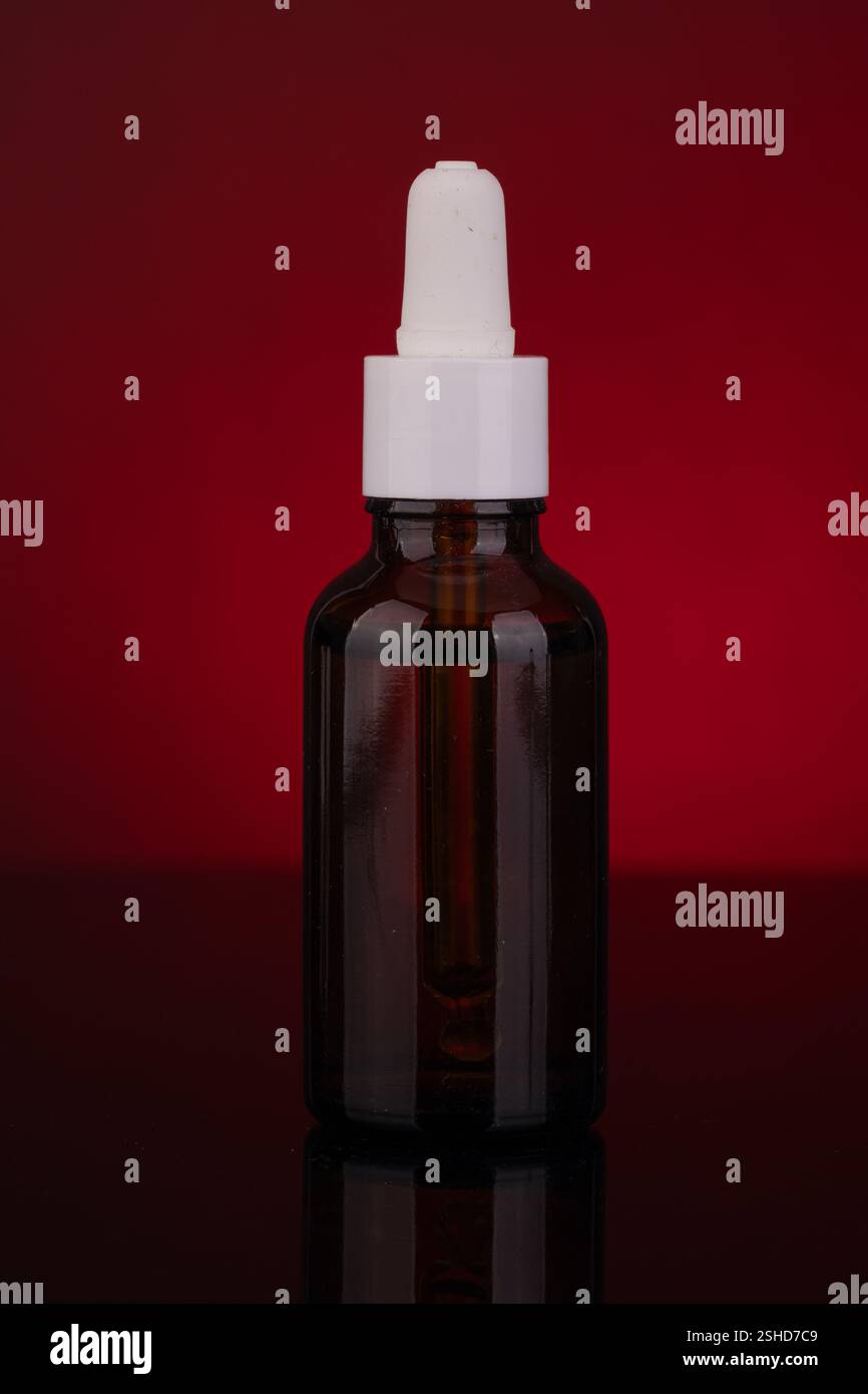 Amber Glass Dropper Bottle with White Cap on Red Background Stock Photo ...