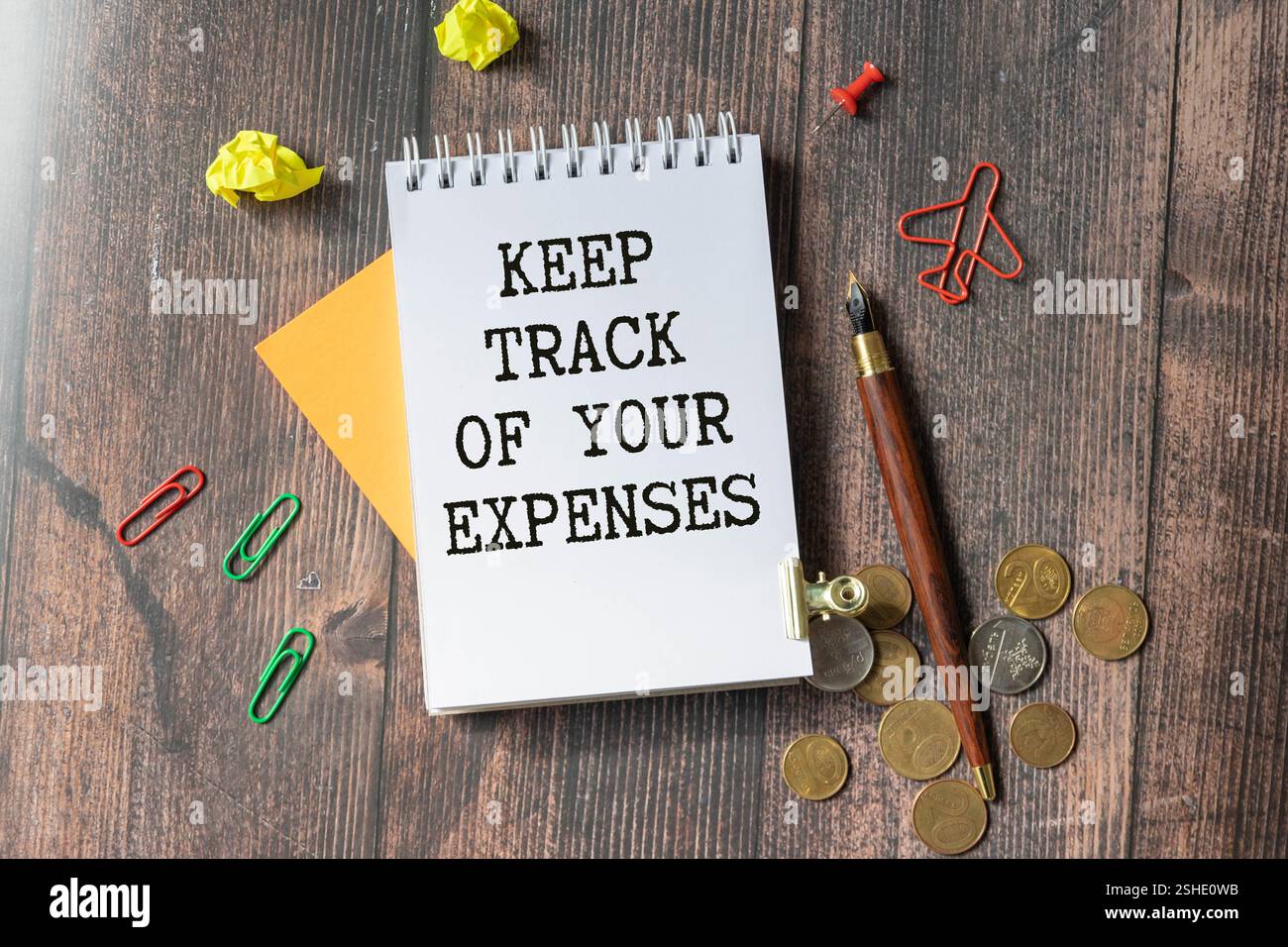 White card with the text Keep track of your expenses on wooden desk ...