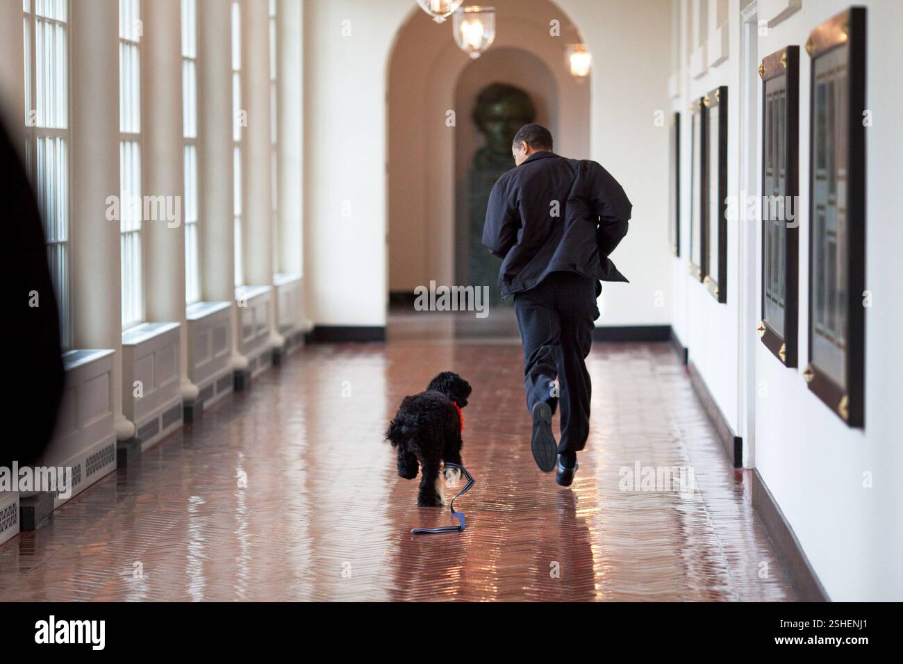 President Barack Obama runs down the East Colonnade with family dog "Bo ...