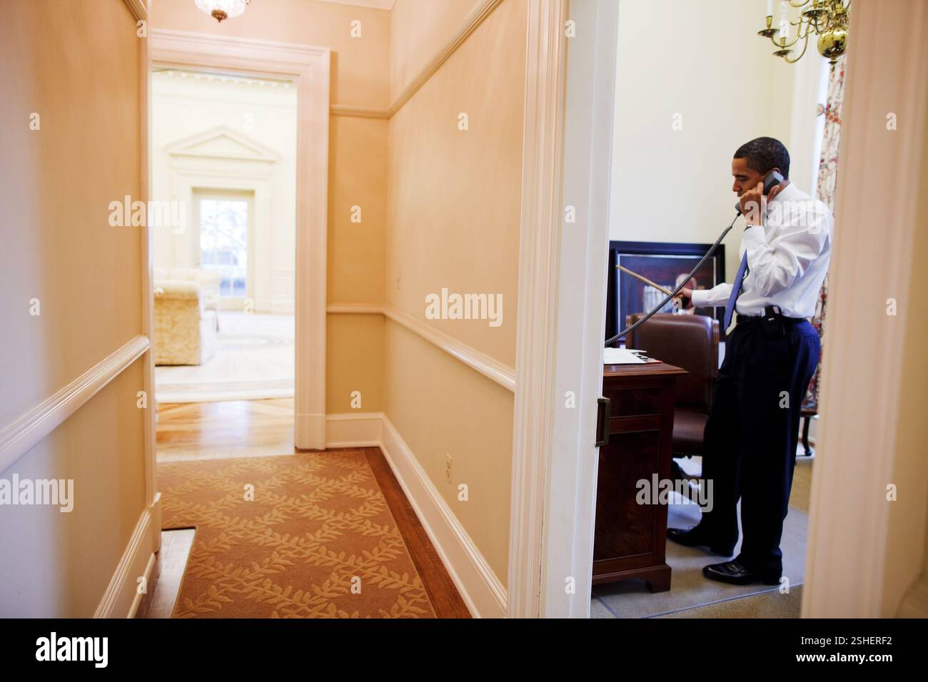 President Barack Obama takes a phone call in his private study off the ...