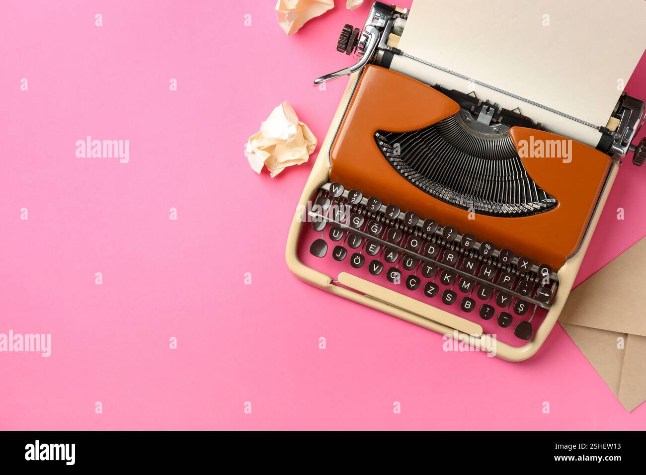 Vintage typewriter, crumpled paper and envelope on pink background ...