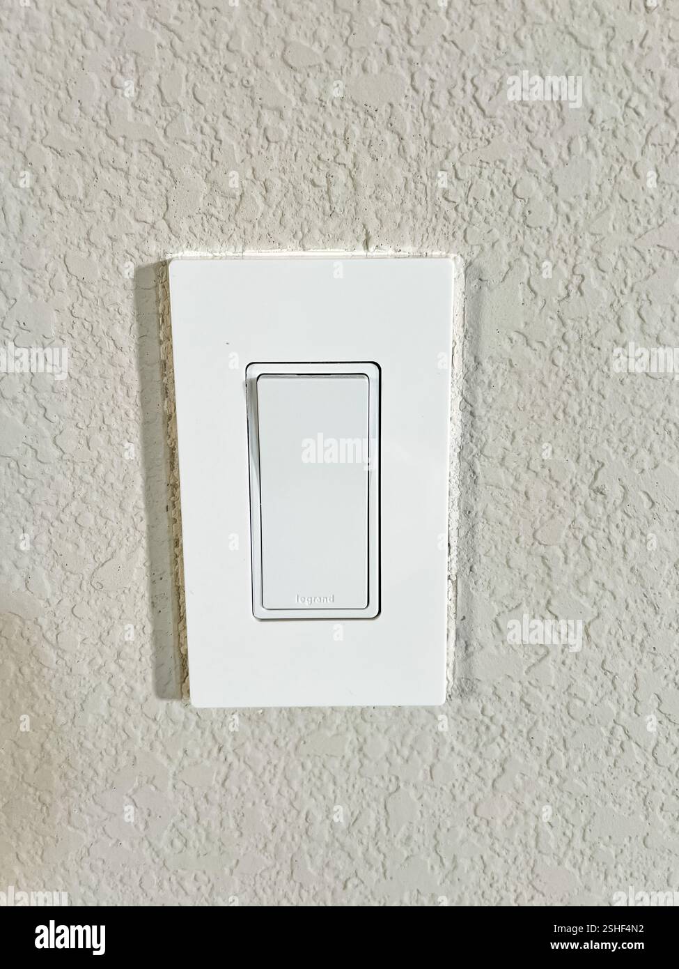 White modern light switch on textured wall Stock Photo - Alamy
