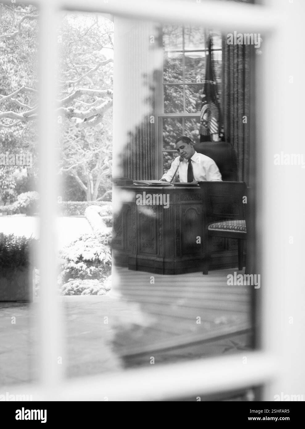President Barack Obama talks on the phone in the Oval Office 1/27/09 ...