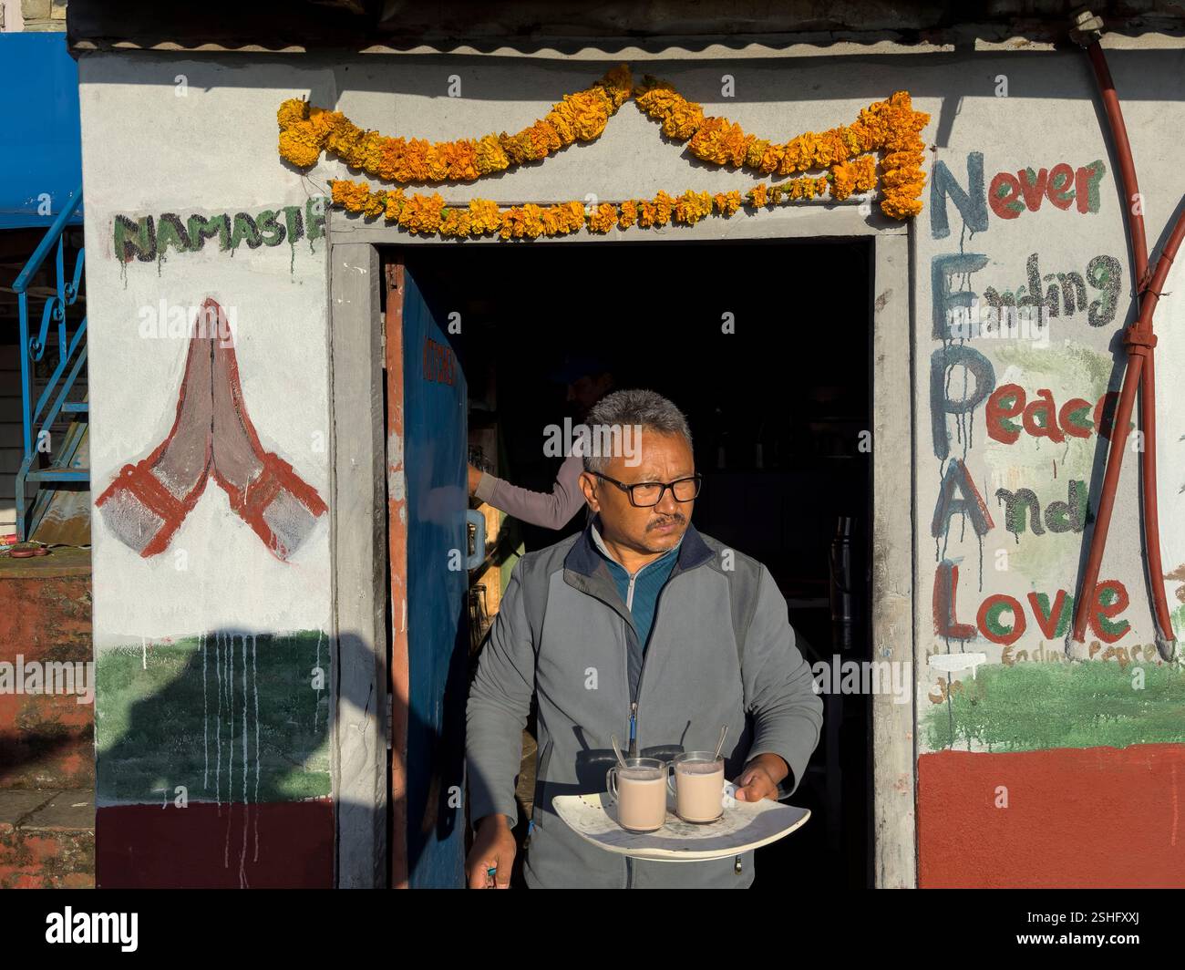 A Nepali man serves tea at High Camp on the Mardi Himal Trek to ...
