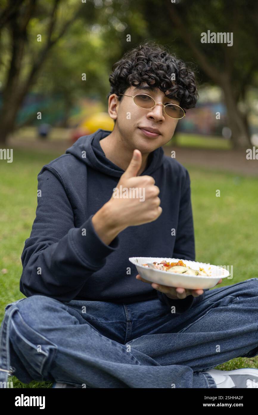 A young person showing a thumbs up after enjoying a delicious meal ...