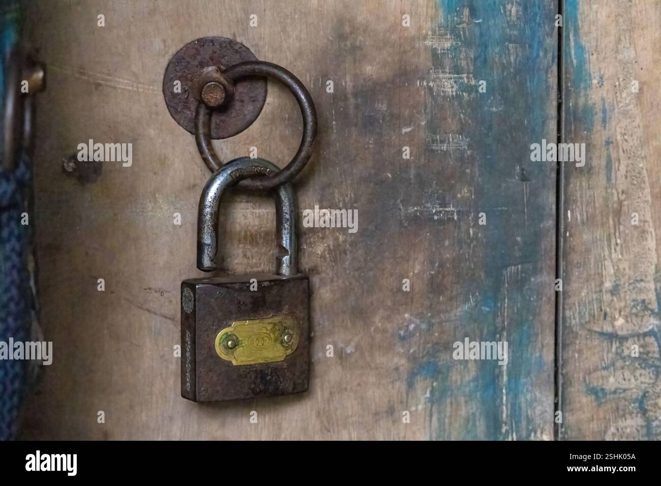 A close-up shot of an old, rusty door lock, hanging unlocked on a ...